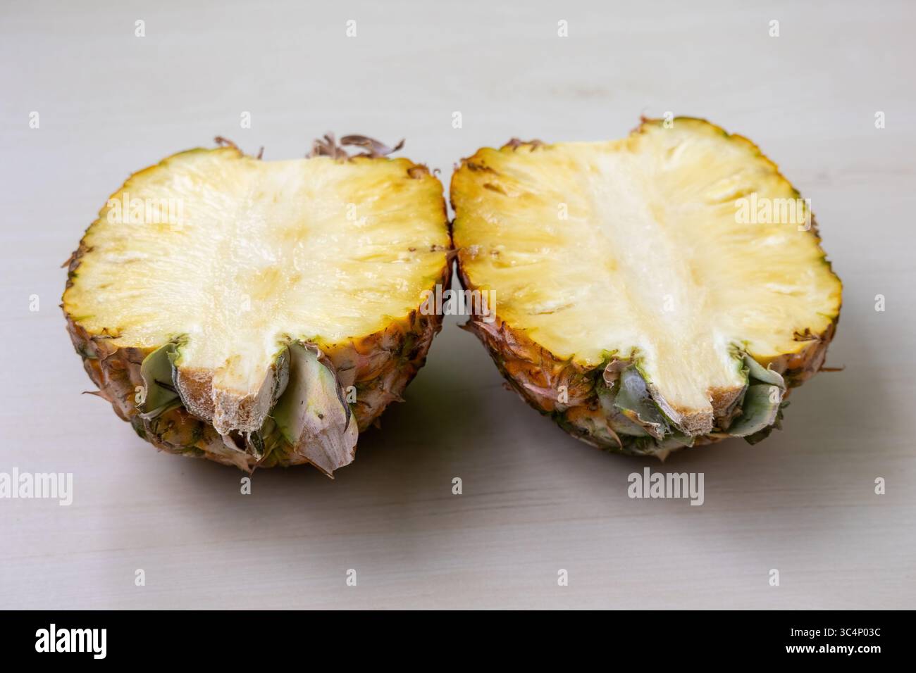 Close-up of a perfectly ripe pineapple, sliced open revealing its juicy ...