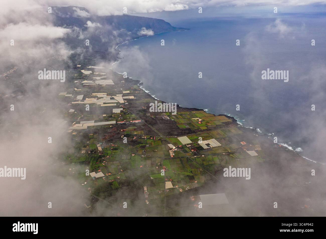 Aerial view of the contrasting dark volcanic rock and green ...