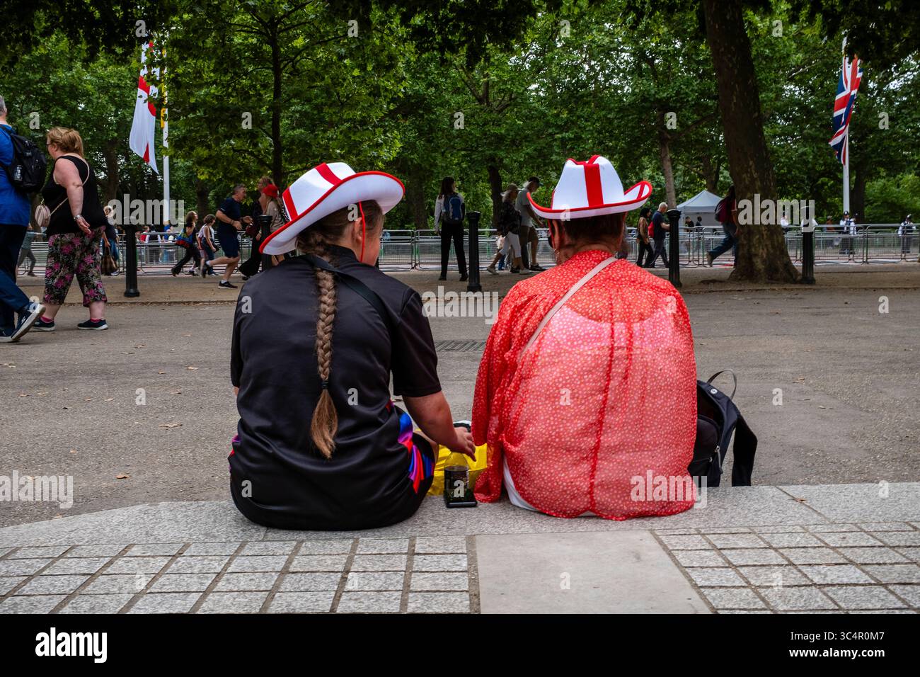 Two England supporters wearing cowboy hats sitting resting after the ...