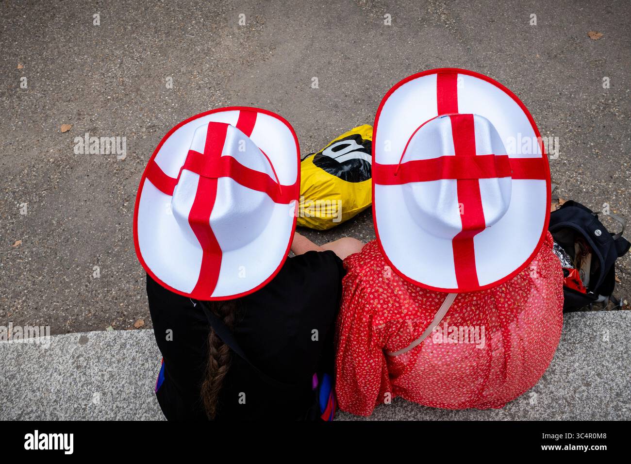 Two England supporters wearing cowboy hats sitting resting after the ...