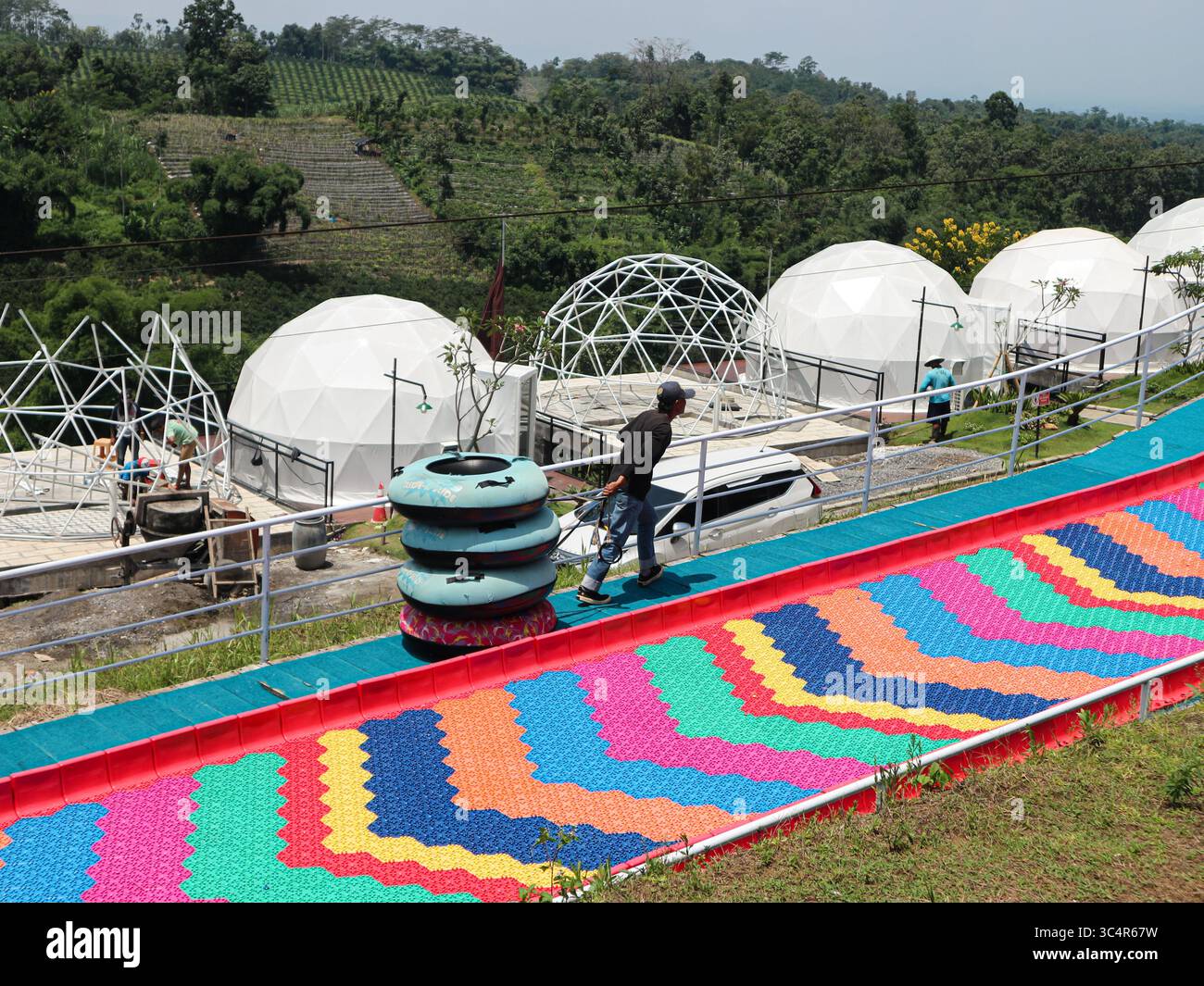 a man is pulling a stack of inflatable tubes used in a rainbow slide ...