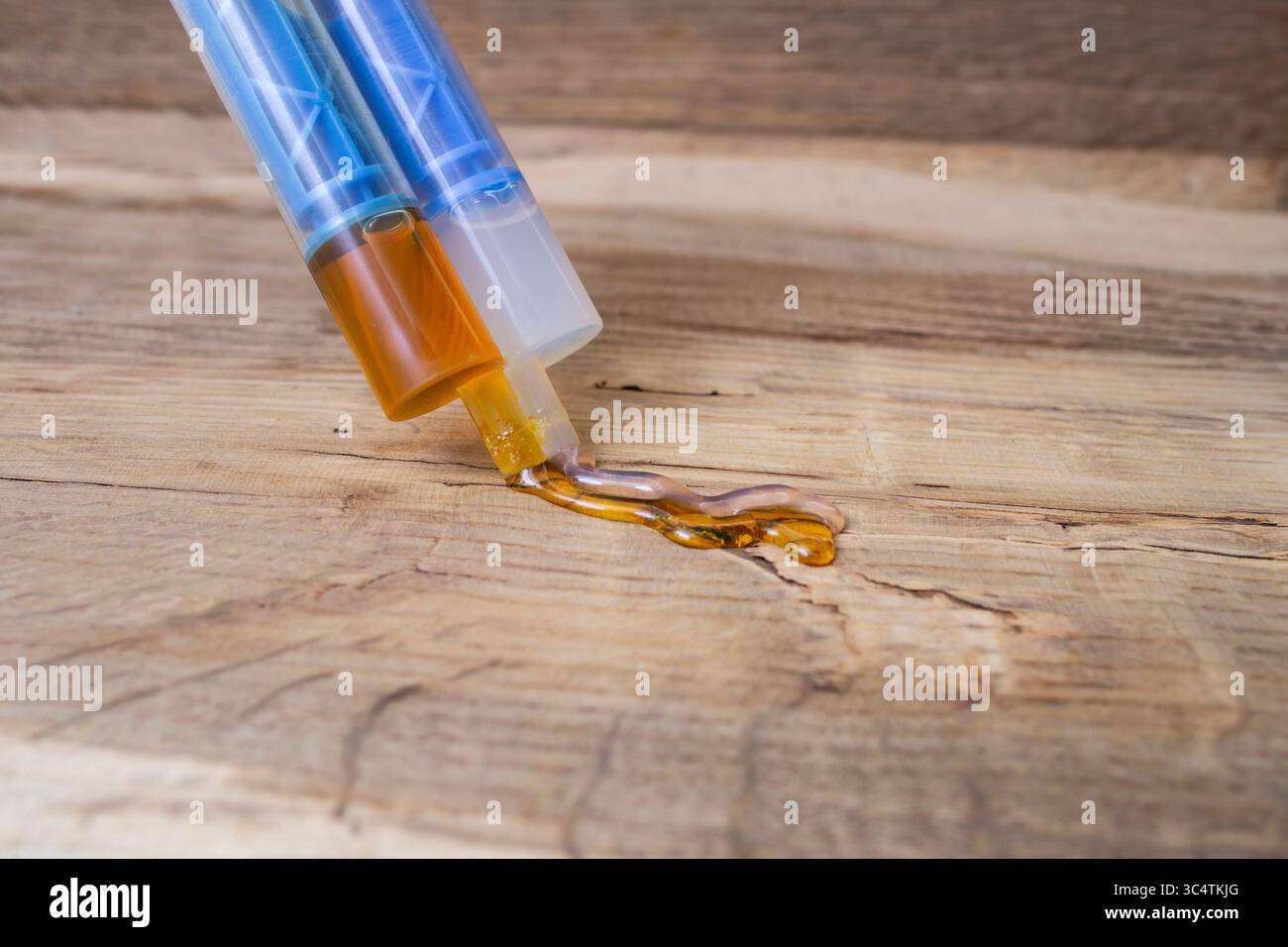 Double syringe with epoxy gel glue spilling on genuine brown leather ...