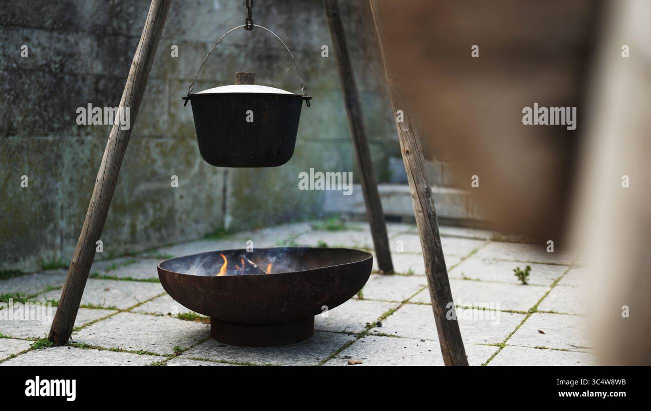 Medieval pot hanging over fire with cooking food Stock Photo - Alamy