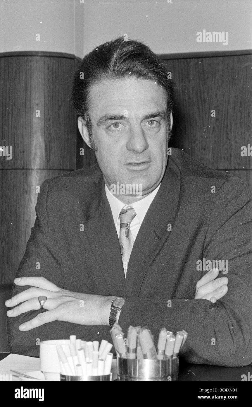 Man in dark suit sits Black and White Stock Photos & Images - Alamy