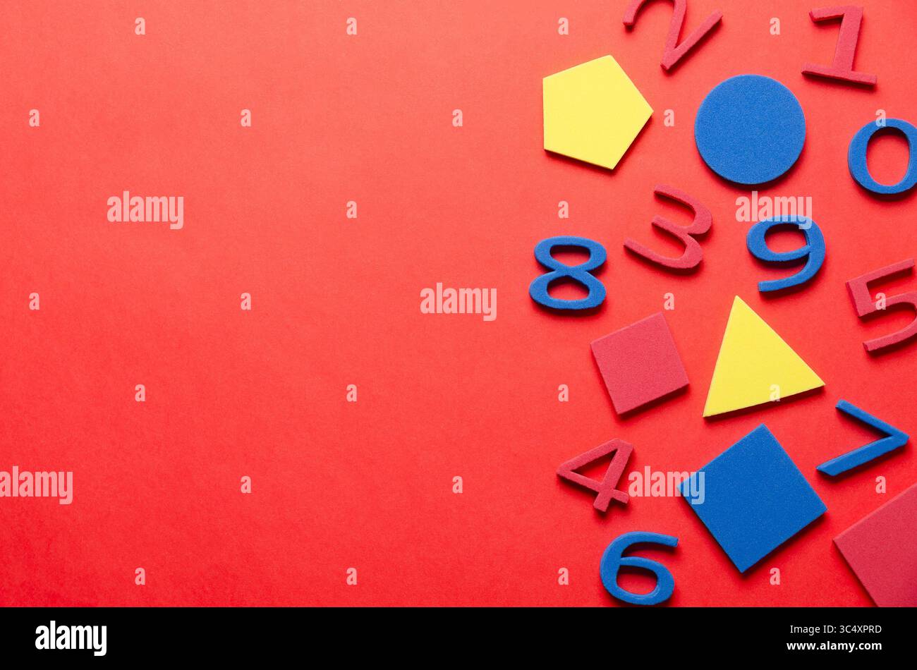 Colorful foam numbers and geometric shapes on red background and copy ...