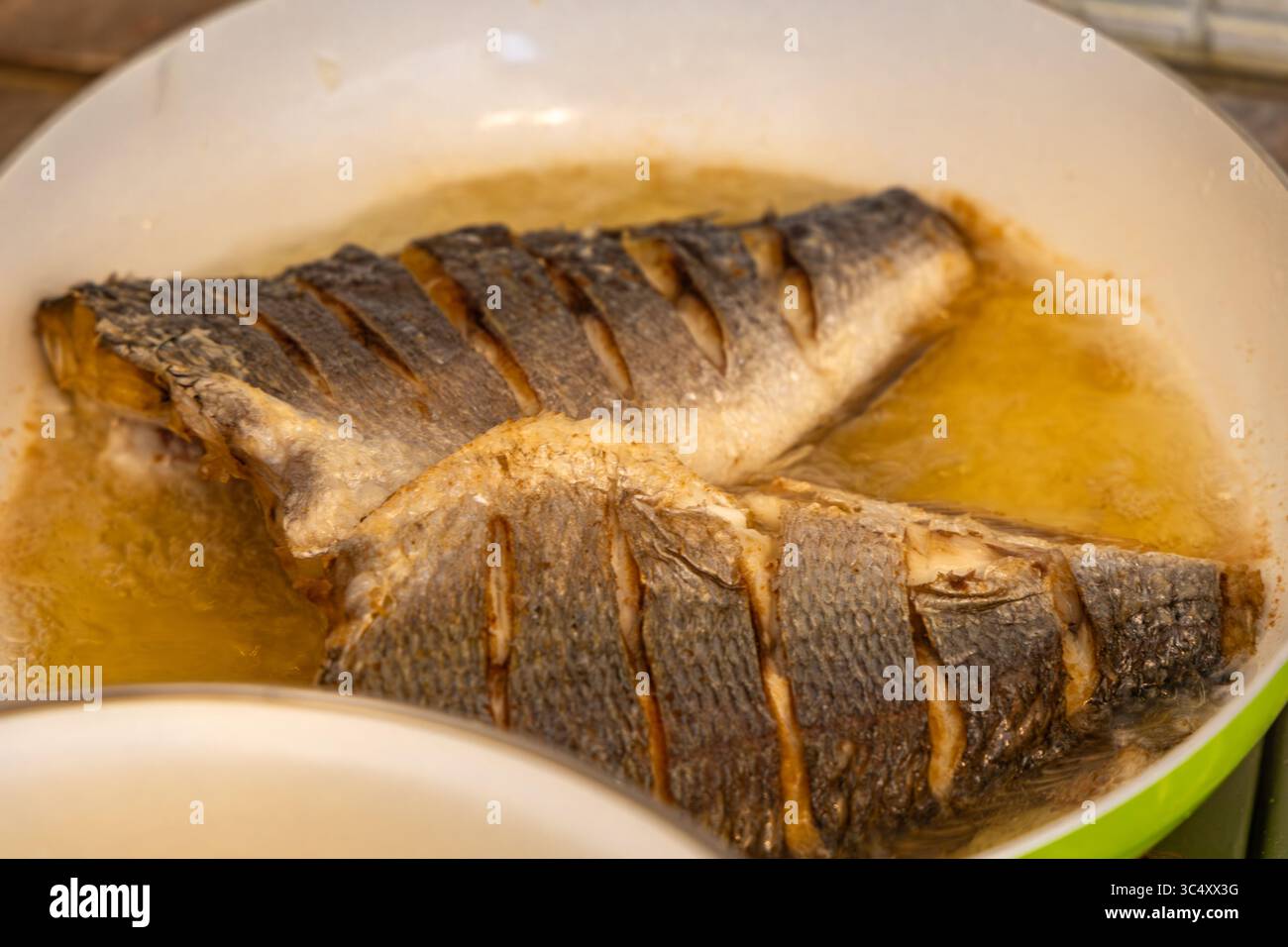 Two pieces of fresh fish fried in a pan, healthy food, fish seasoned ...