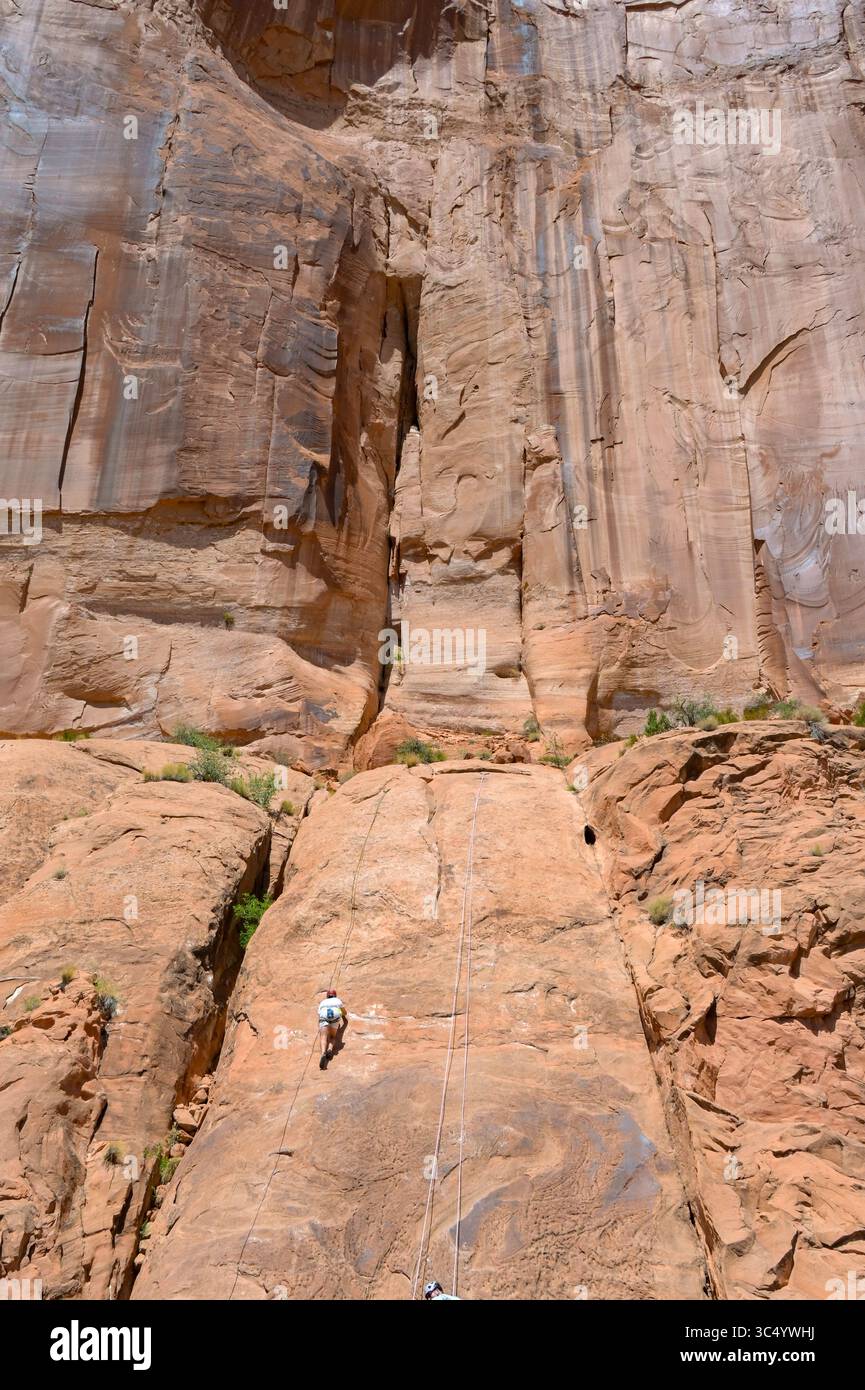 Moab, Utah, USA - 25 May 2025: Person climbing a sheer rock using ropes ...
