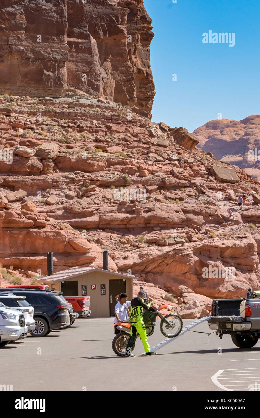 Moab, Utah, USA - 25 May 2025: Two people unloading a scrambler ...