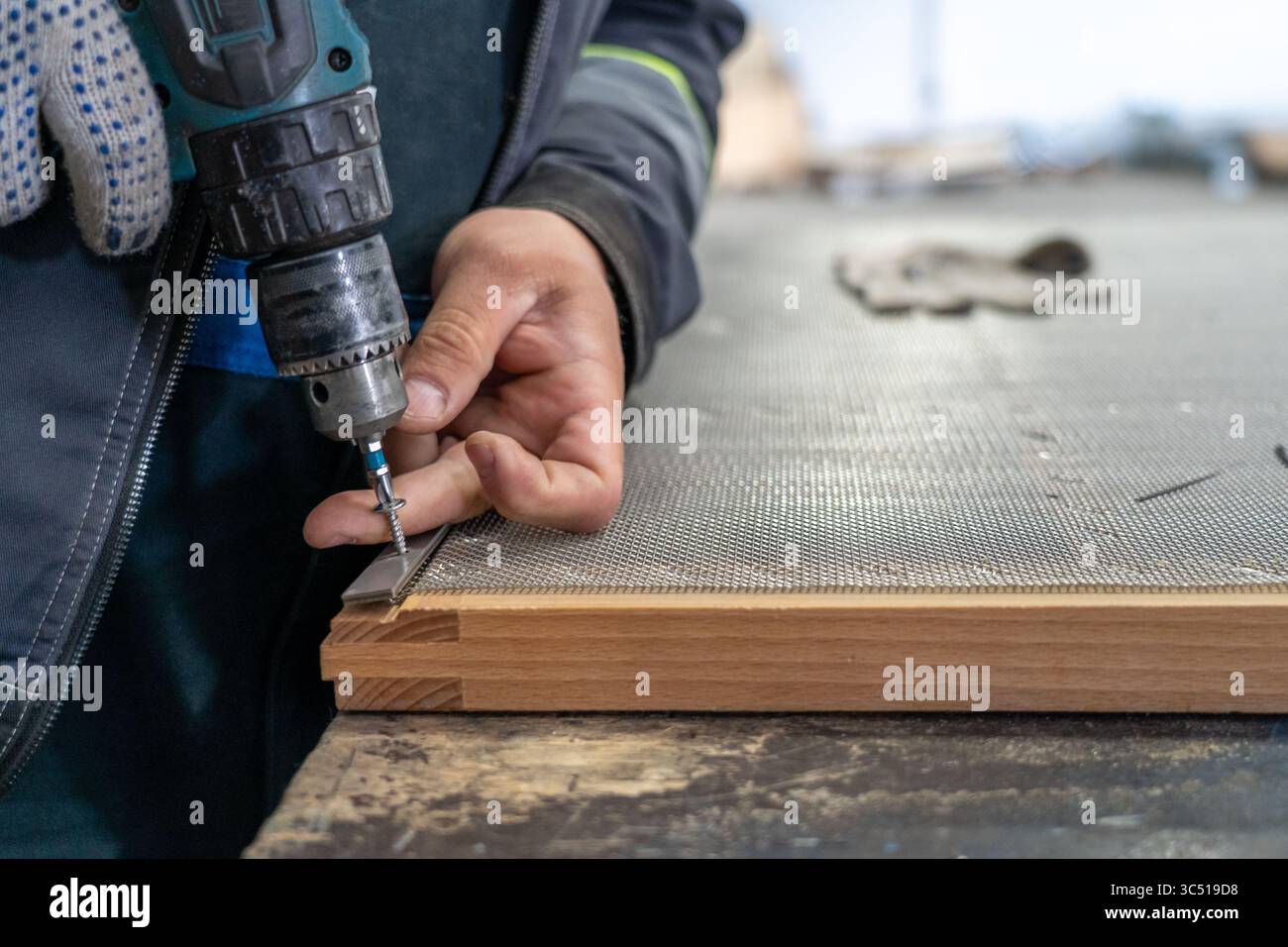 Worker using electric screwdriver manual assemble wooden frame with ...