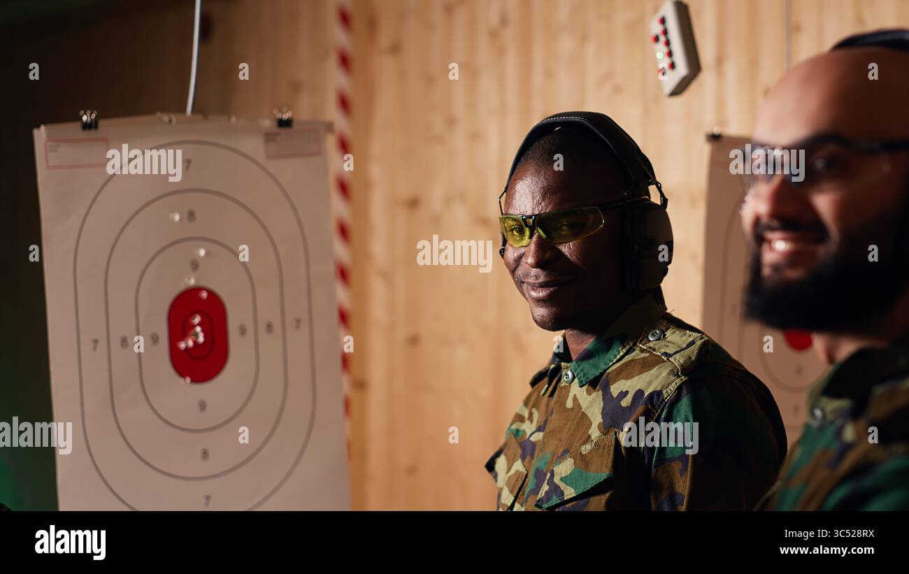 Portrait of happy army soldiers in shooting gallery looking at targets ...