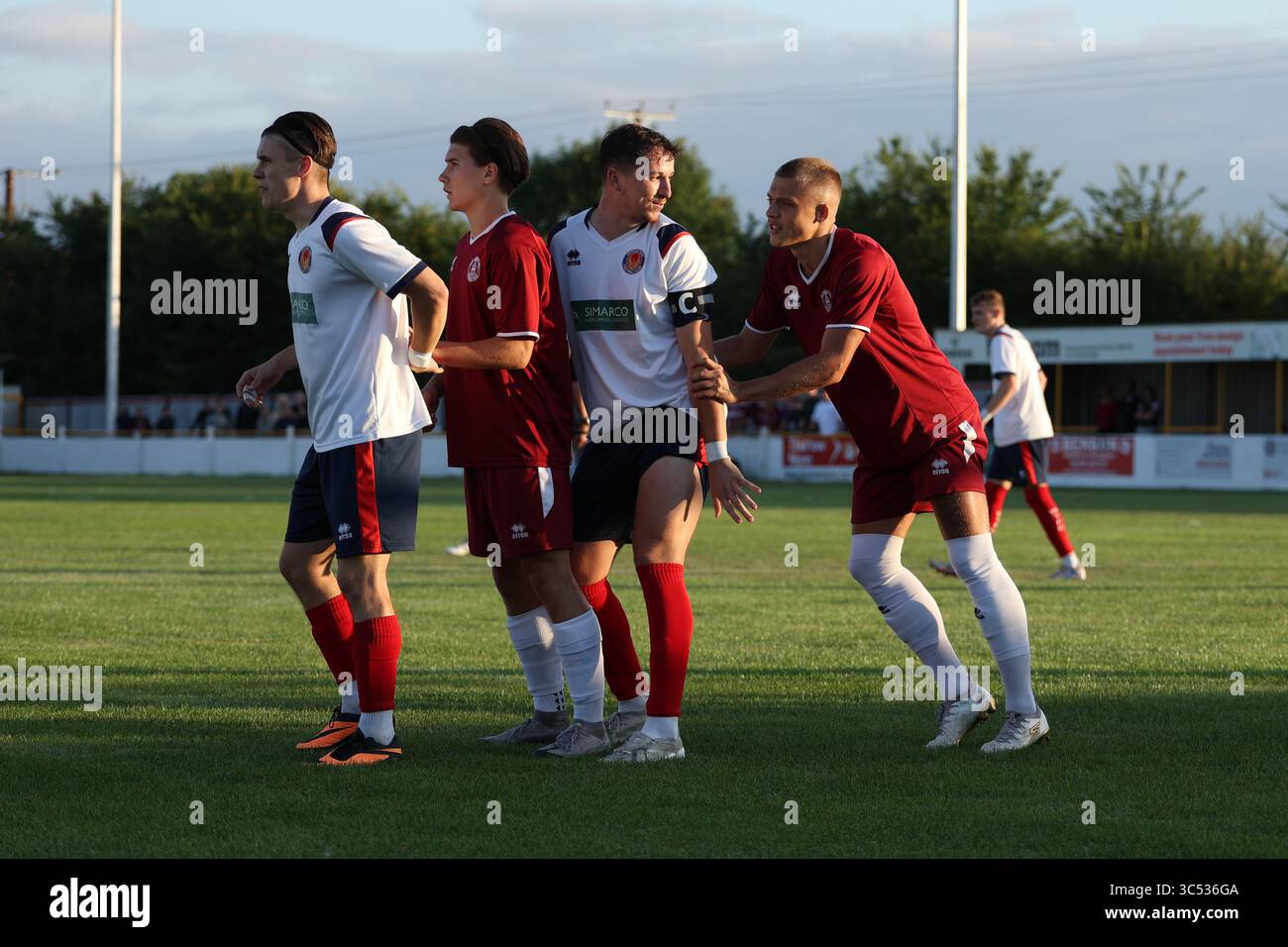Witham Town FC and Chelmsford City FC players hold each other whilst in ...