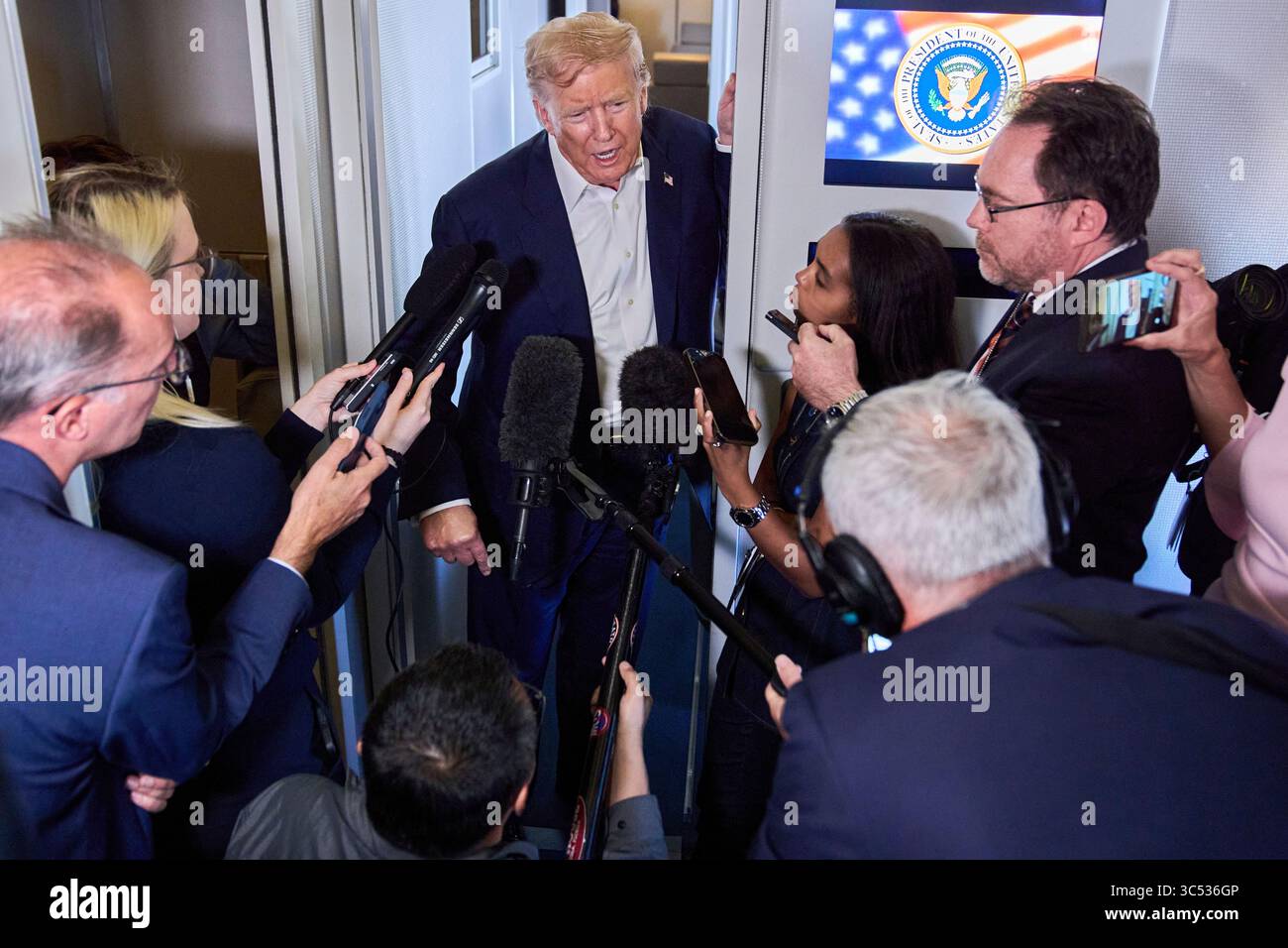 President Donald Trump speaks with reporters aboard Air Force One after ...
