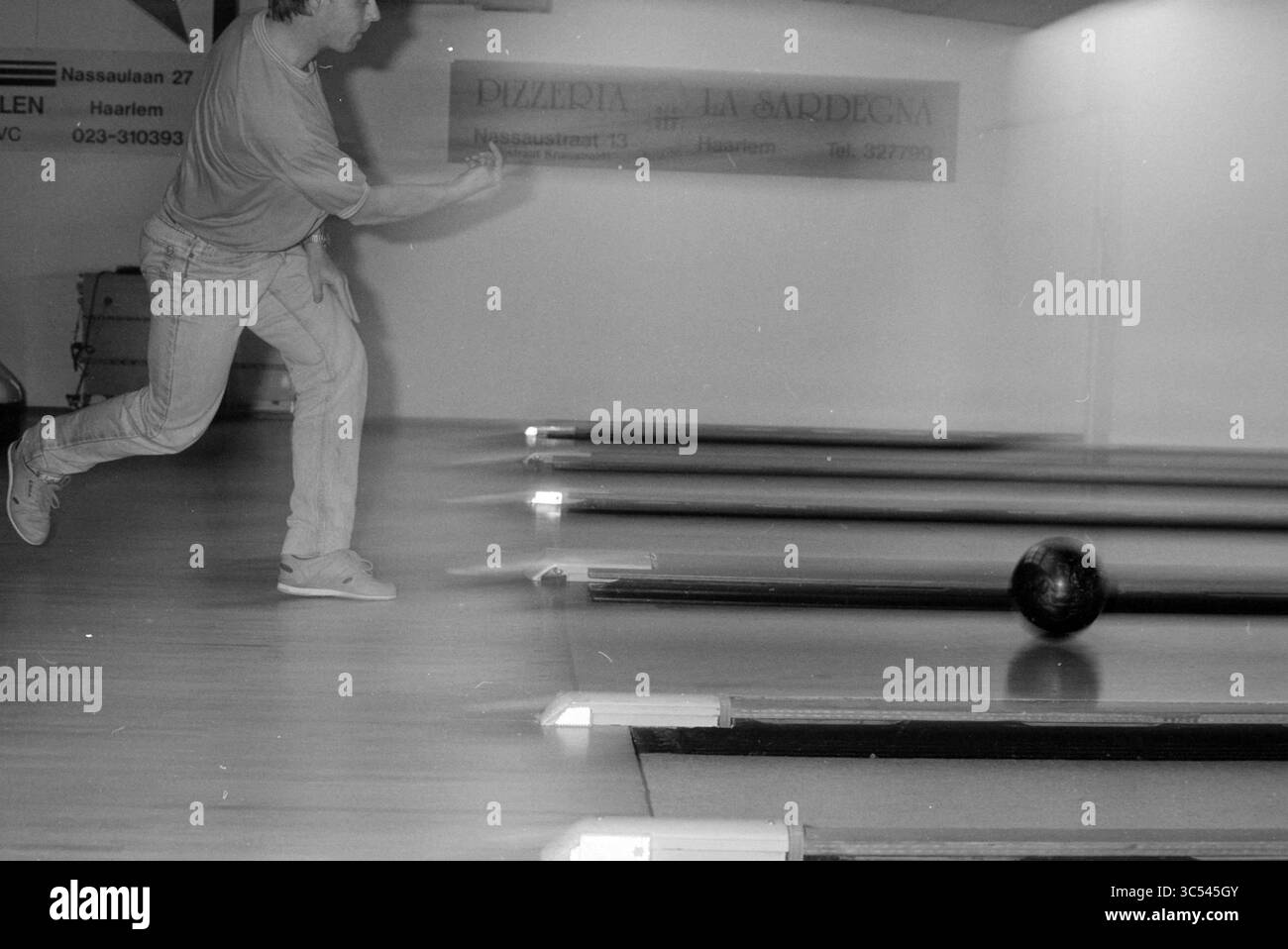 Bowler rolls bowling ball down Black and White Stock Photos & Images ...