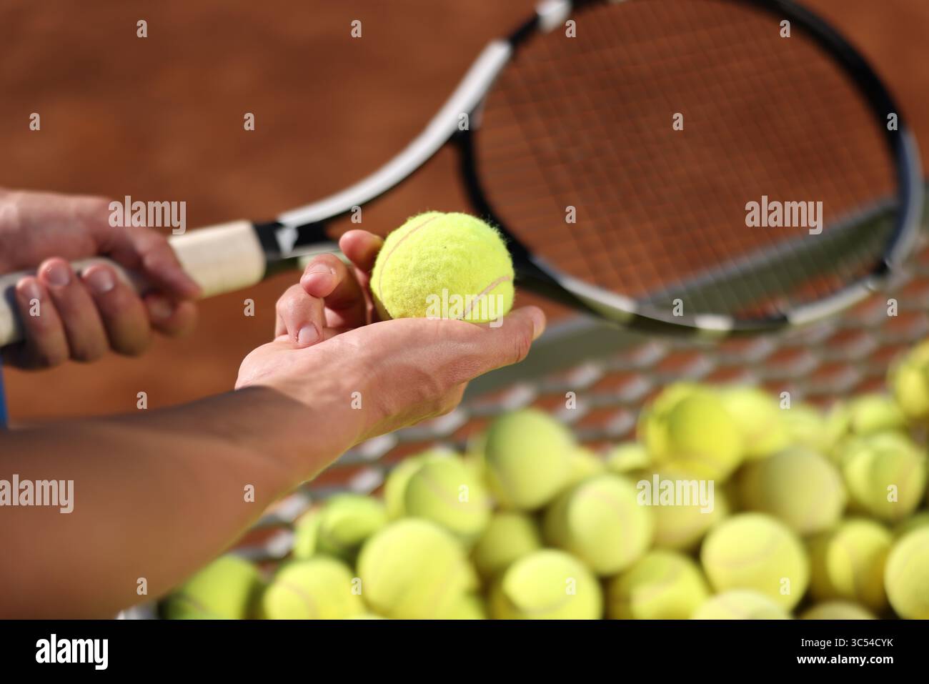 Man taking tennis ball out of cart at court, closeup Stock Photo - Alamy