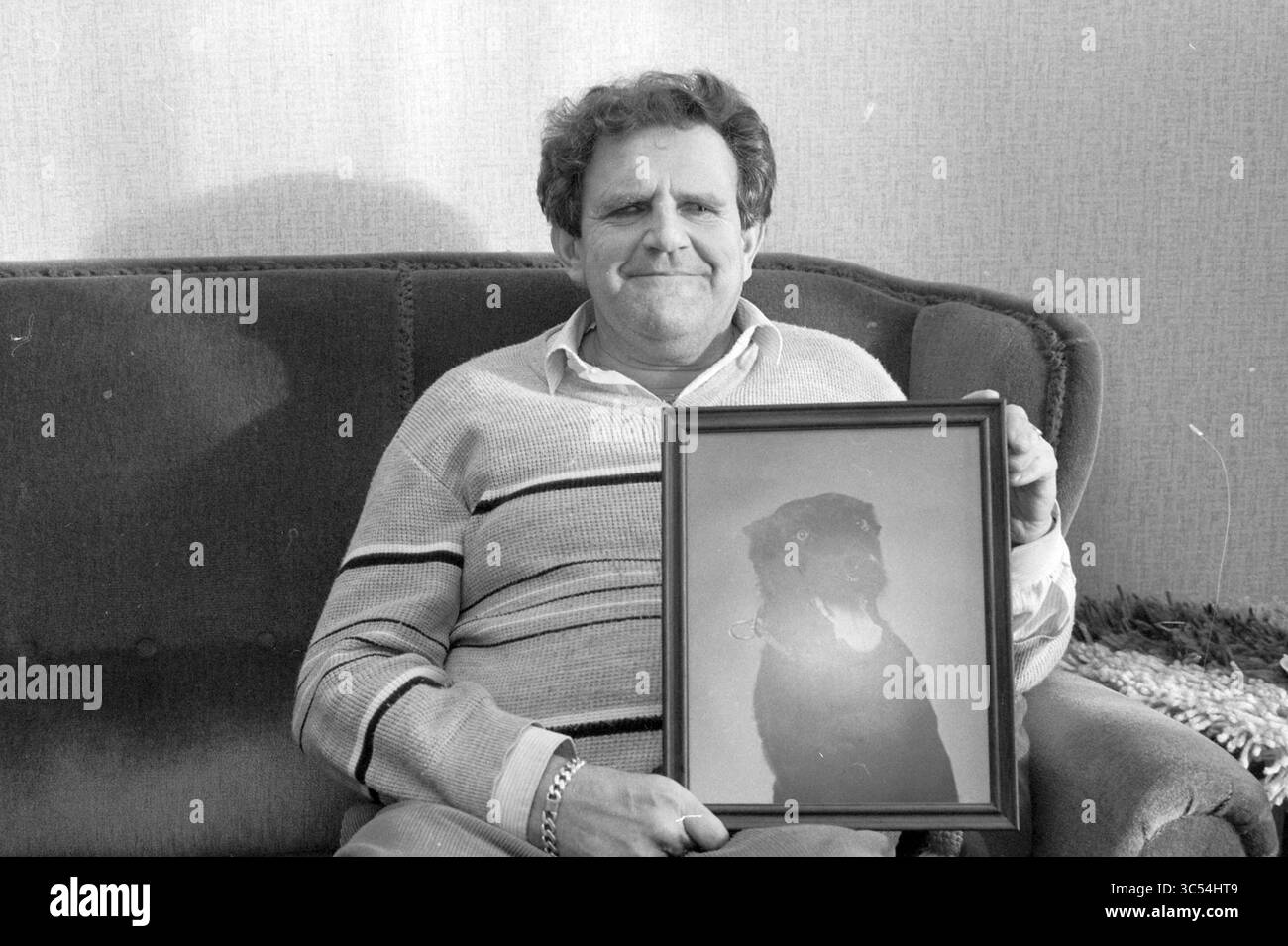 Man in sweater holding Black and White Stock Photos & Images - Alamy