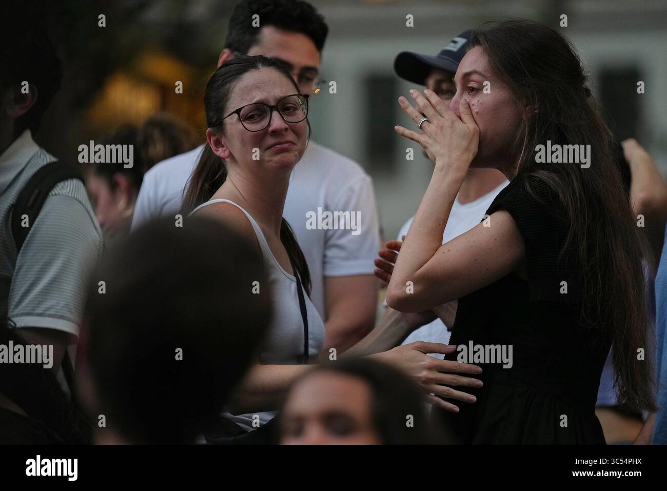 People react while attending a vigil at Bryant Park for the people ...