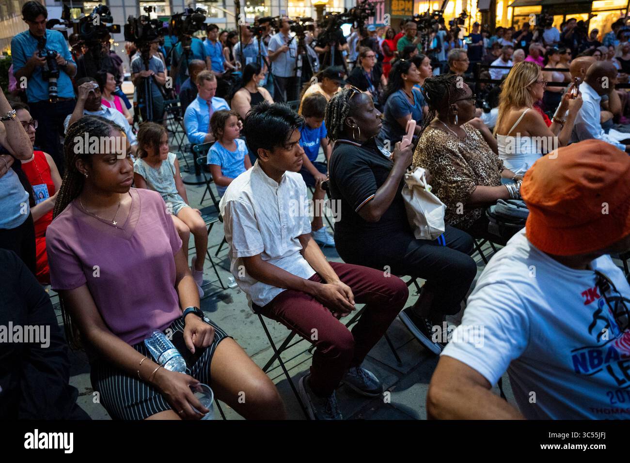 People listen during a vigil for the four people killed in the previous ...