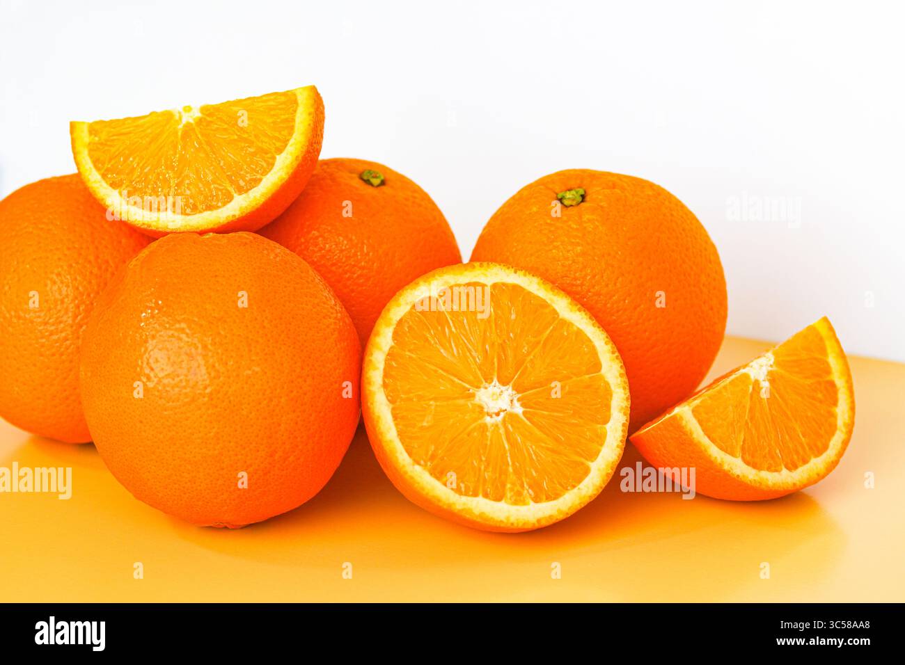 Vibrant Sunkist oranges. Four whole, one halved, and two slices ...