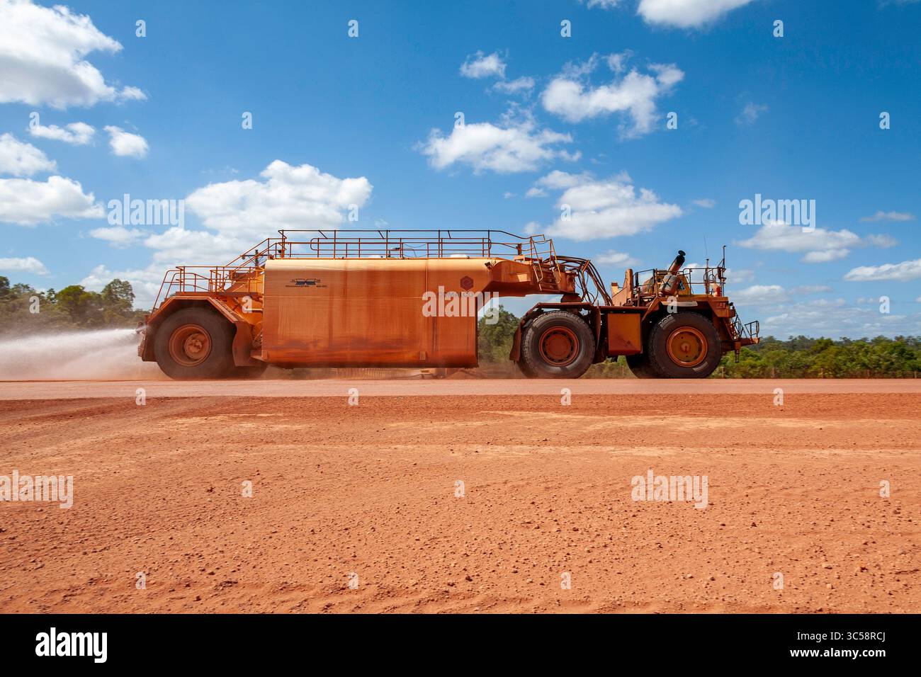 water tanker spraying mining truck motoring past dust huge massif heavy ...
