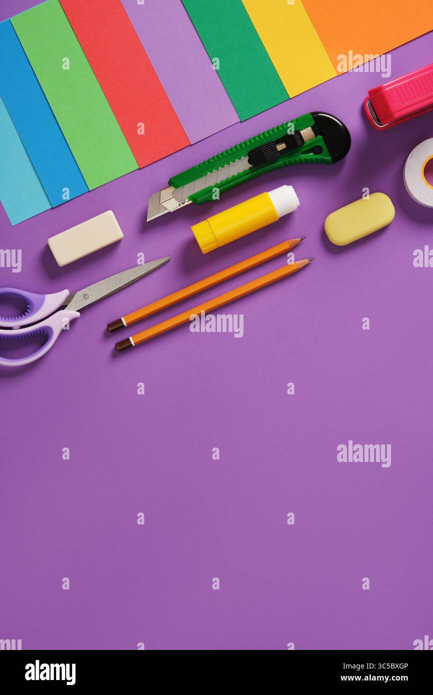 Paper craft table: scissors, knife, pencil, eraser, colored paper on ...