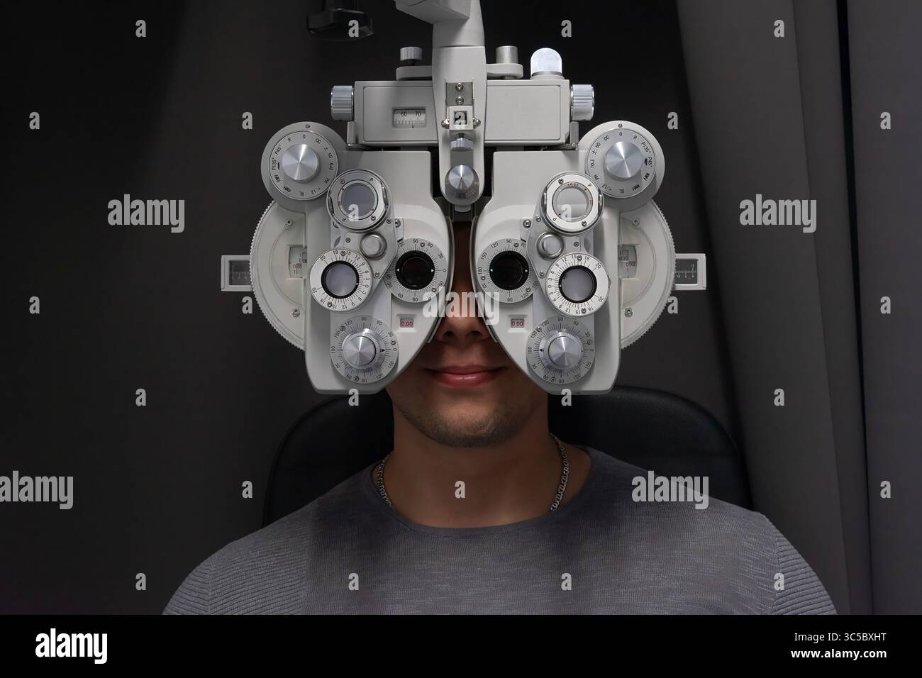 Eye exam with phoropter during vision checkup at optometrist office ...
