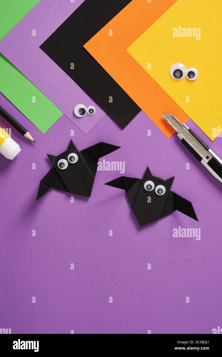 Origami paper bats with goggle eyes on a purple background. Surrounded ...