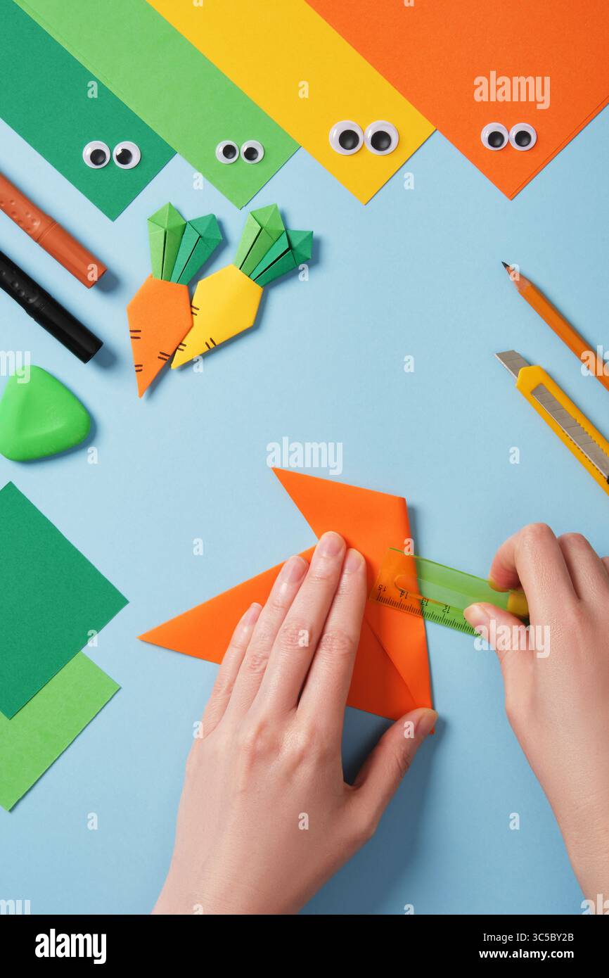 Making origami carrot. DIY project. Bend the corners of the triangle ...