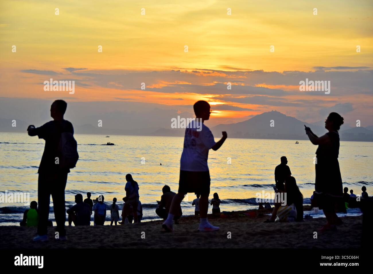 Tourists play at the seaside in Sanya City, southernmost China's Hainan ...