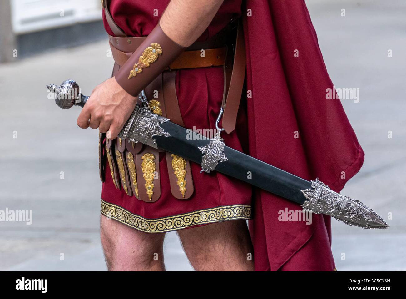 Roman legionary in traditional armor holding an ornate gladius sword ...