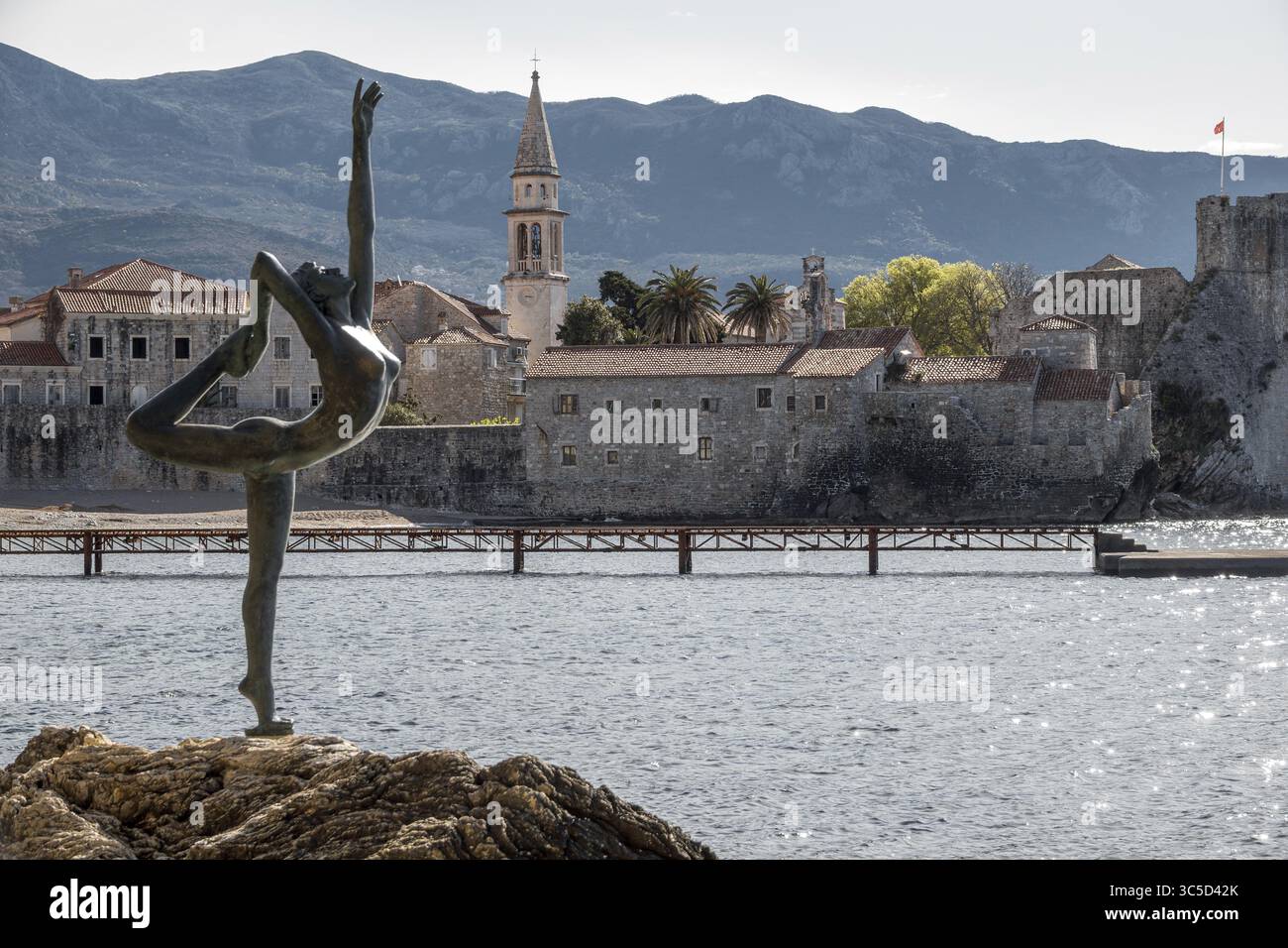 Statue of a ballerina against the background of the old town centre of ...