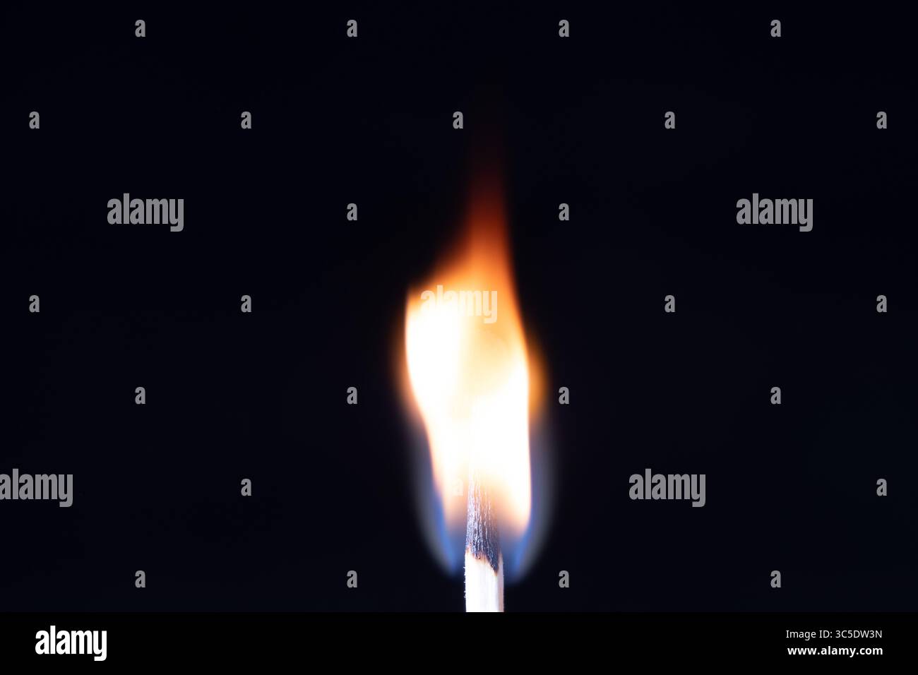 A lit matchstick against a dark background. The flame emanates from the ...