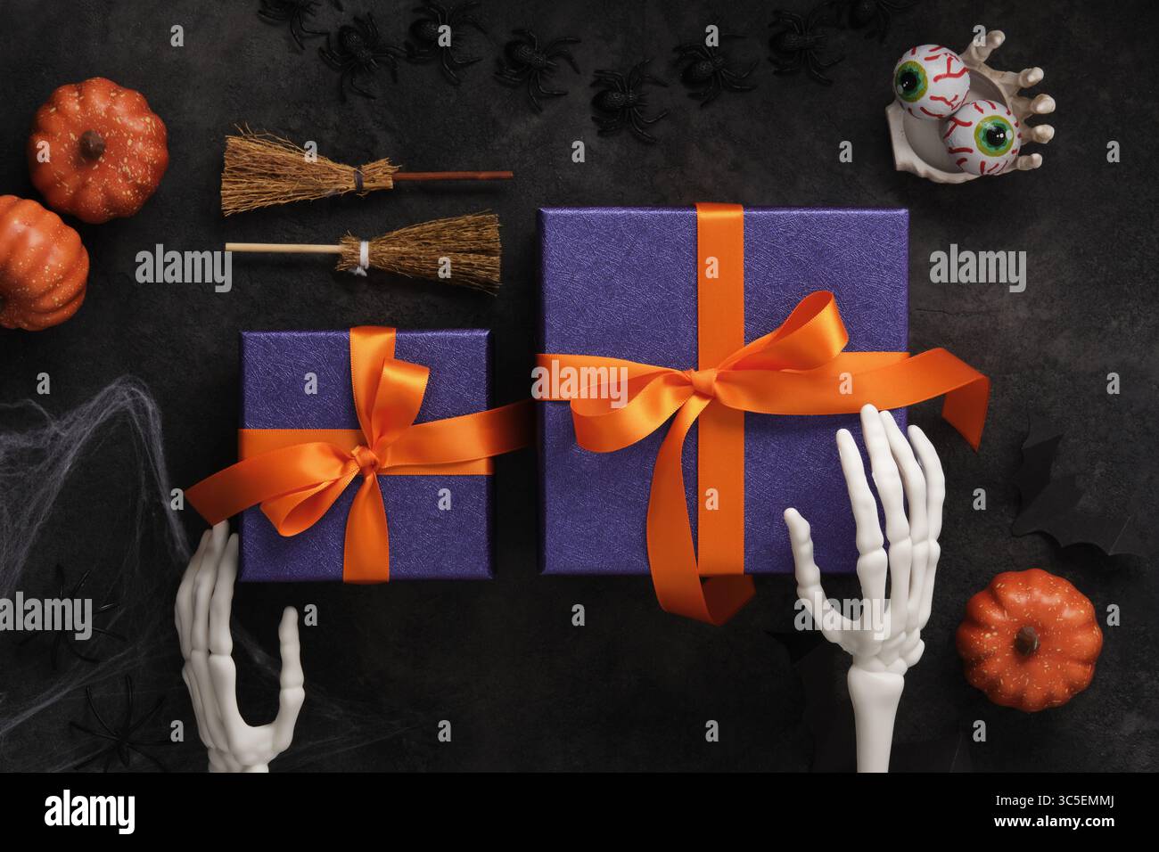 Purple Halloween gift boxes with orange ribbons with skeleton hands ...