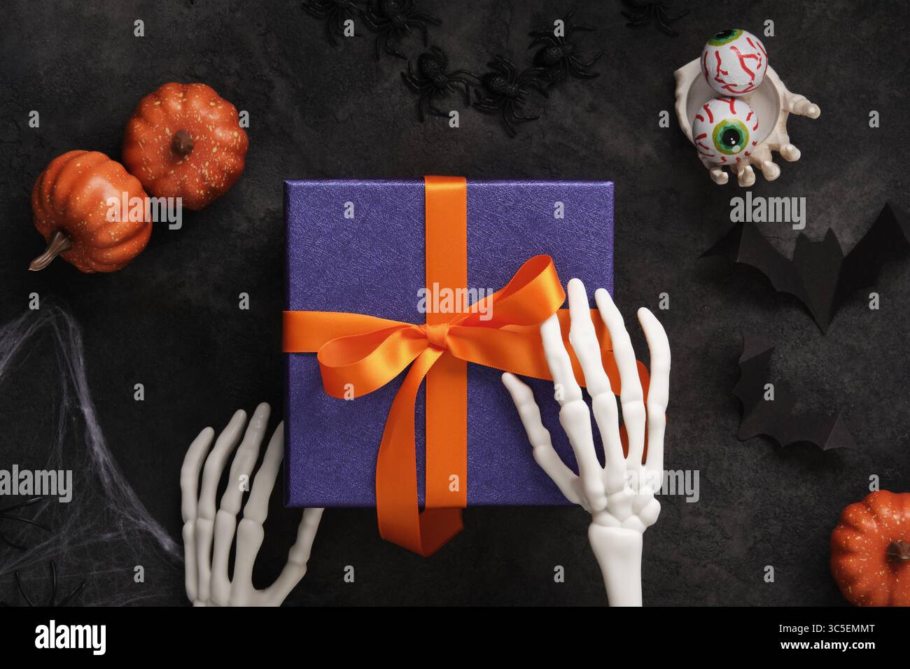 Purple Halloween gift boxes with orange ribbons with skeleton hands ...