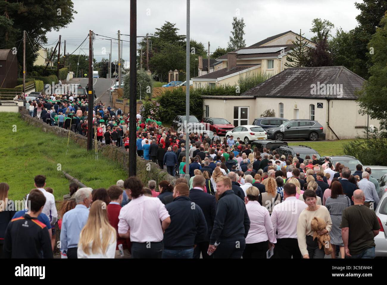 Mourners follow the hearses containing the coffins of murder victims ...