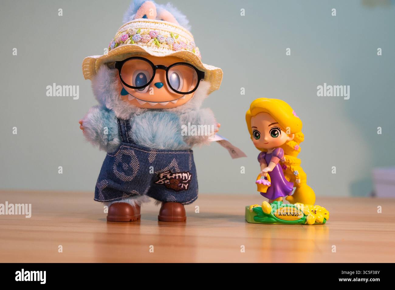 a labubu doll with glasses and a fairy lady toy(horizontal Stock Photo ...