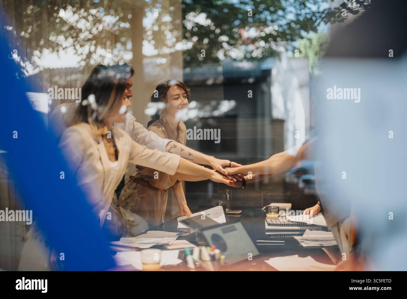 Team celebrating success with hands stacked in a collaborative ...