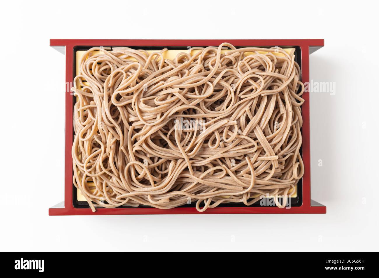 A top-down view of plain zaru soba noodles piled inside a red and black ...