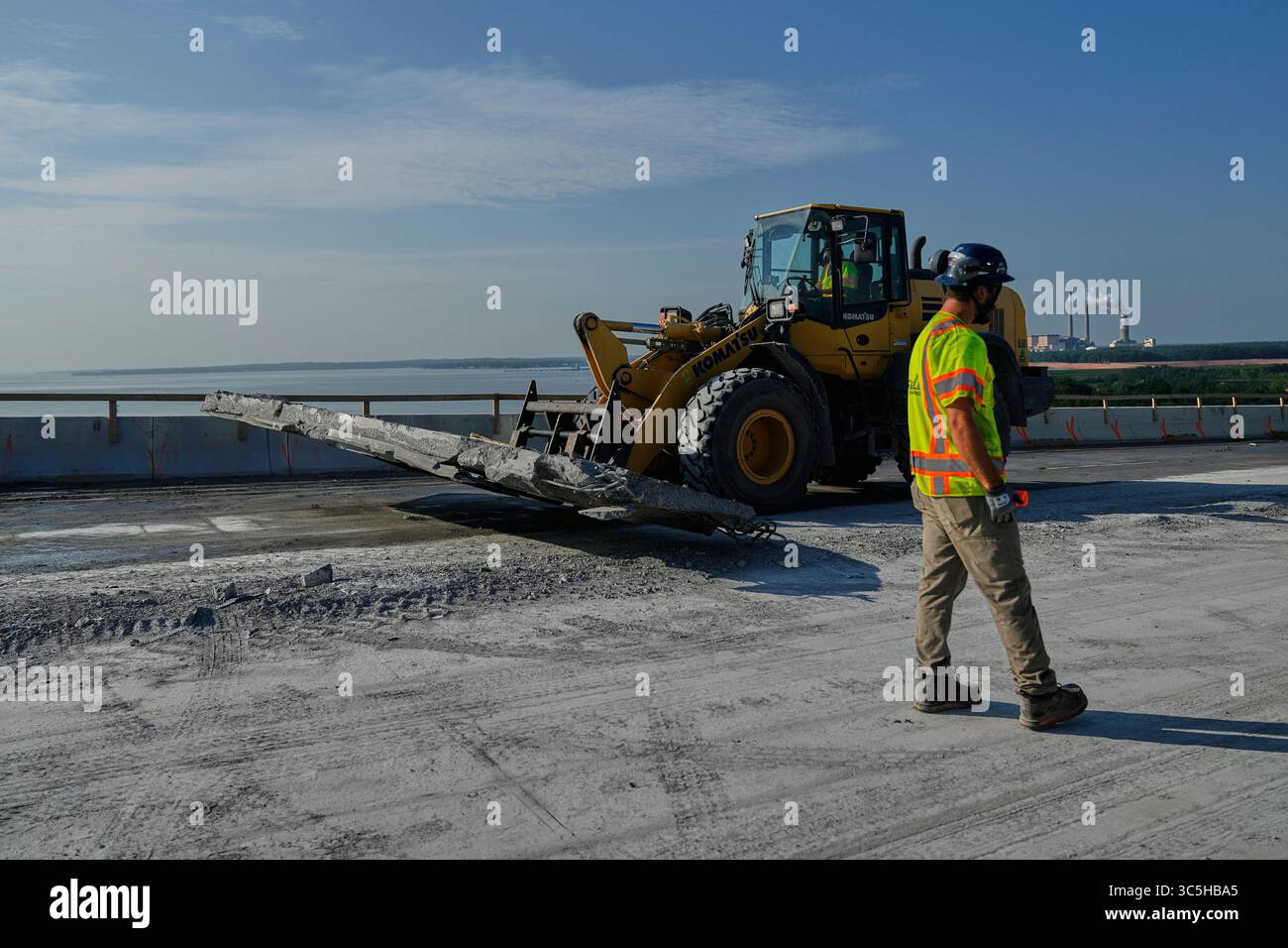 A demolition crew removes a slab of concrete from the remaining ...