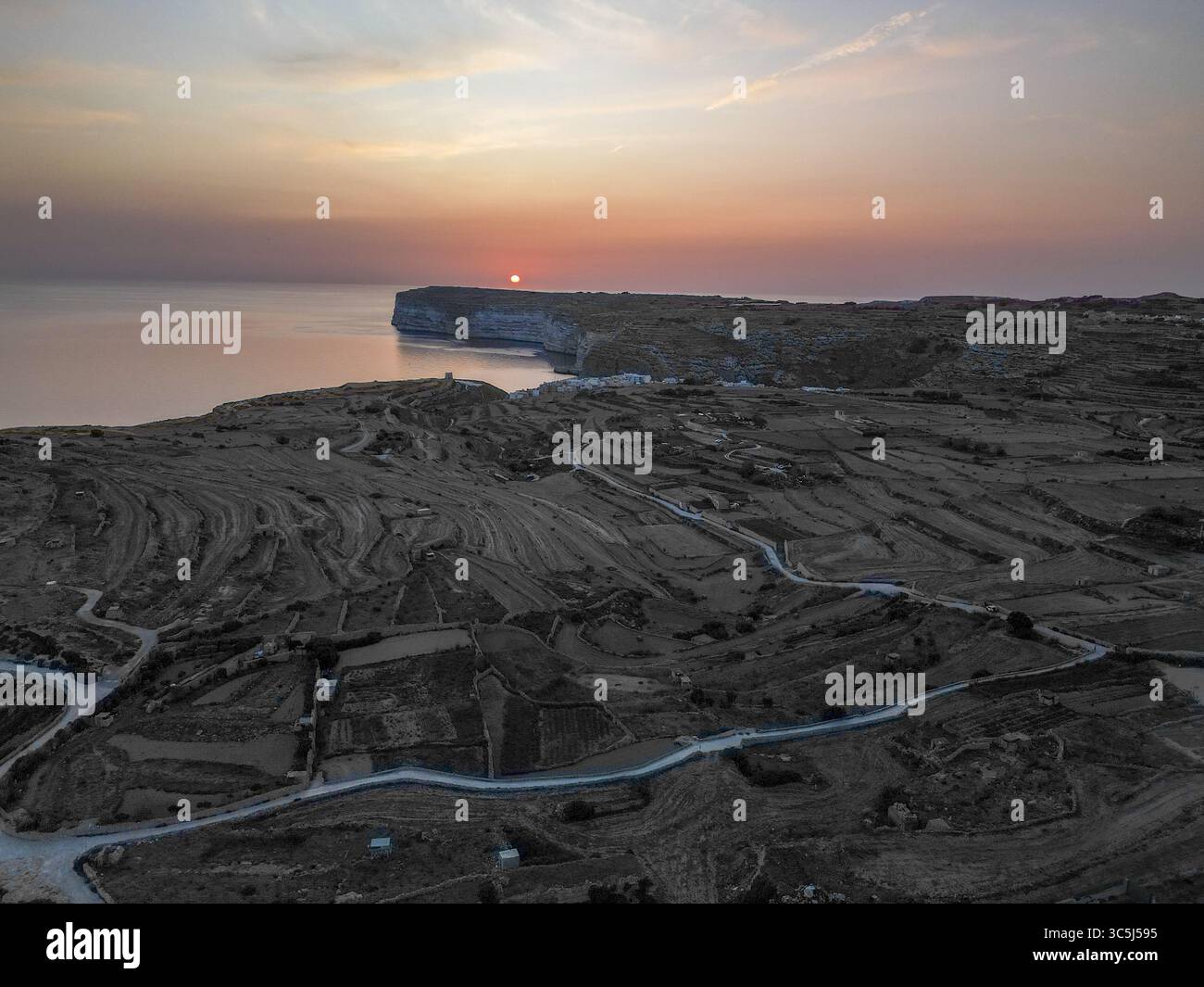 Aerial view of sun kissed horizon over the rugged coastline and ...