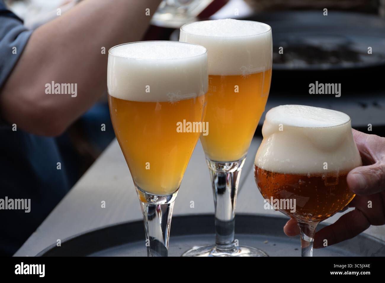 Belgian beer in special glass served outdoor in old brewery in Bruges ...