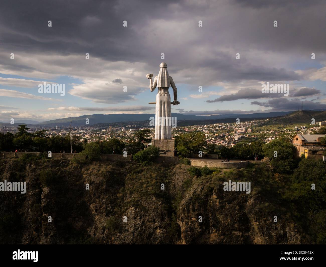 Aerial view of the majestic Kartlis Deda statue, silhouetted against ...