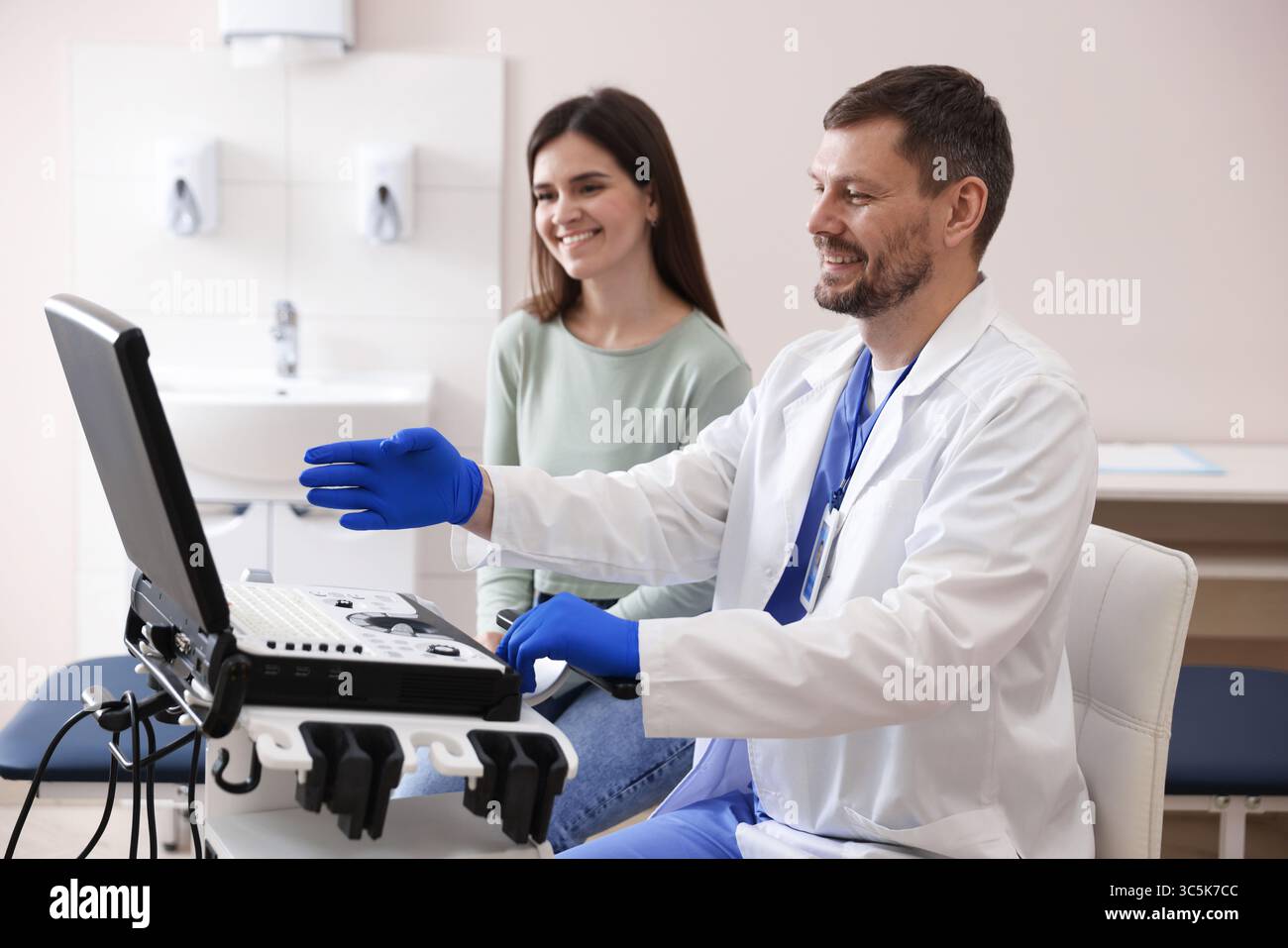 Sonographer showing woman her ultrasound imaging on screen in clinic ...
