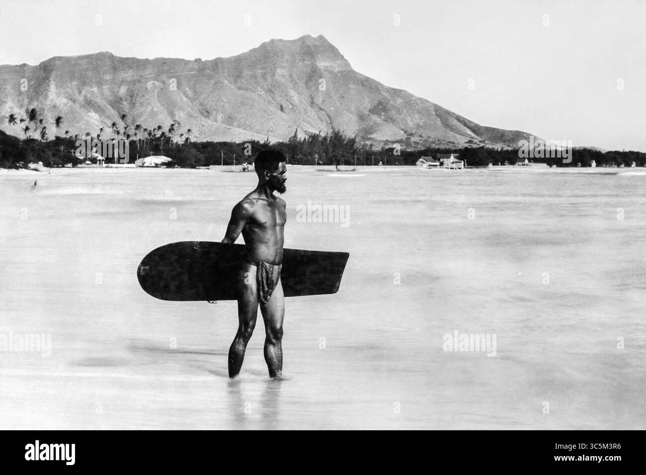 Charles Kauha with Alaia wooden surfboard at Waikiki Beach on Oahu ...