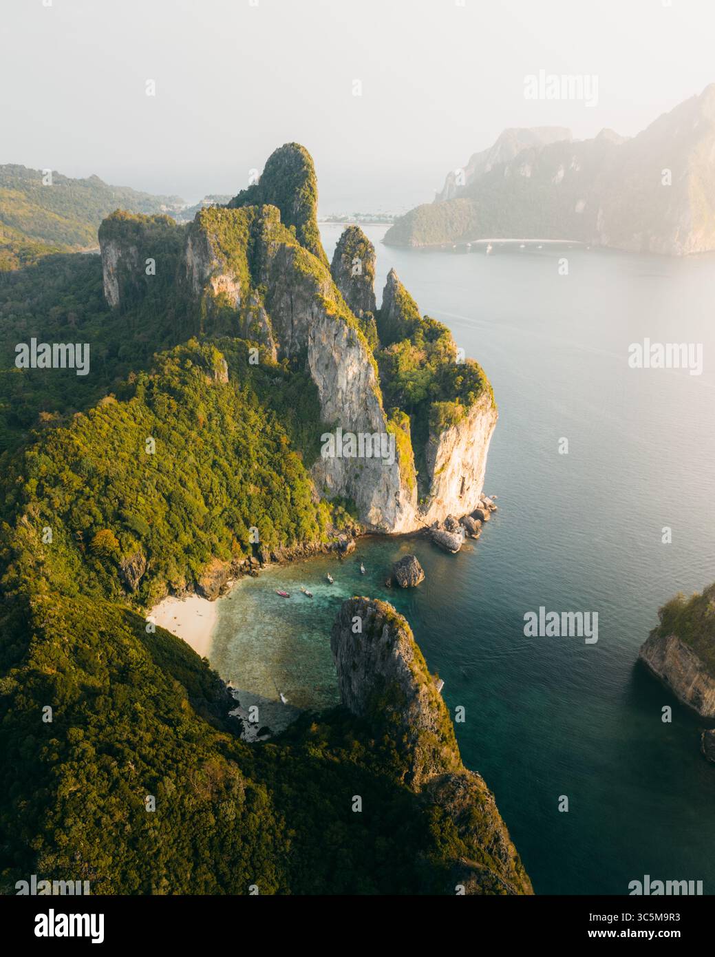 Aerial view of towering limestone cliffs meet the turquoise waters of ...