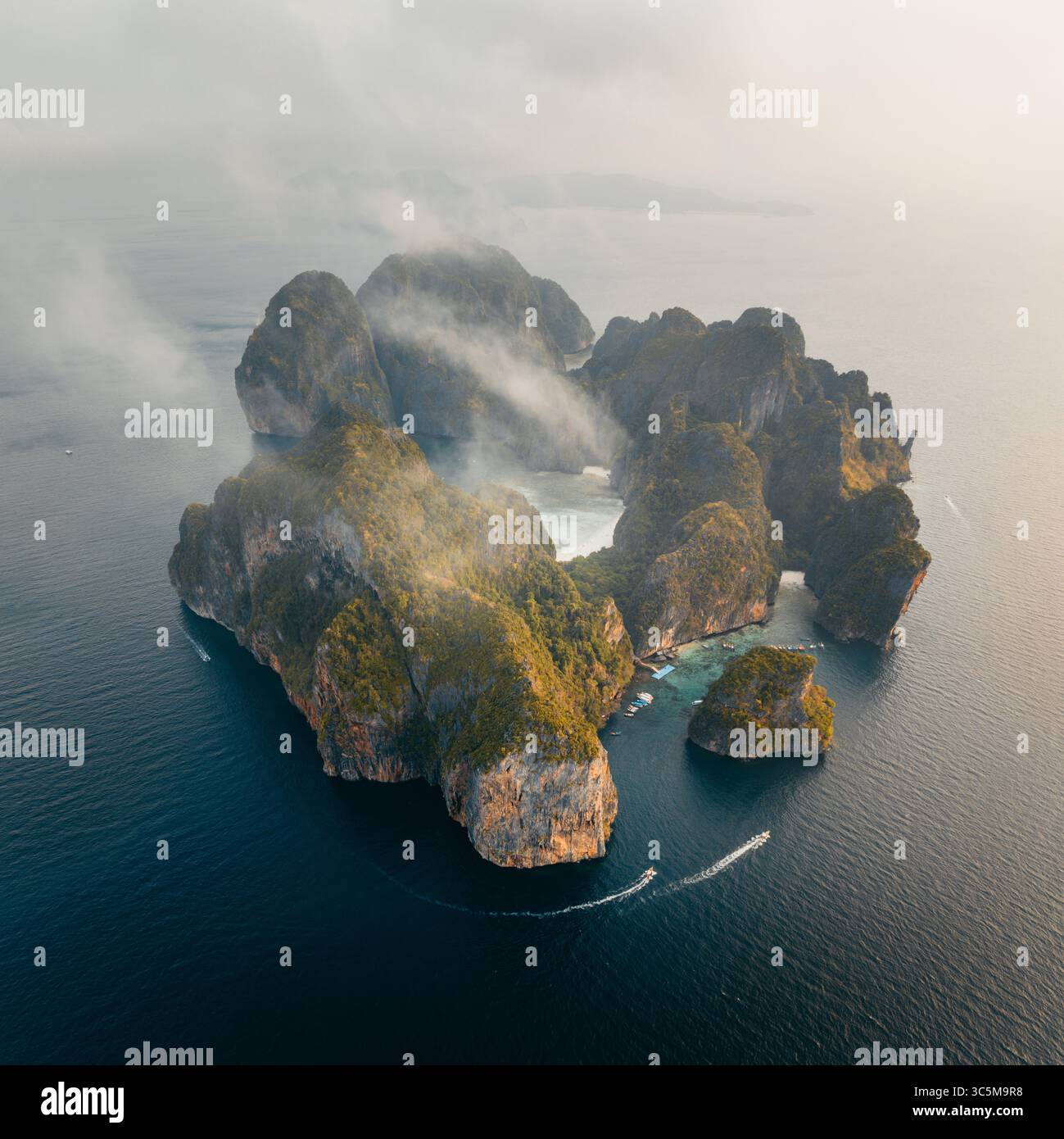 Aerial view of dramatic limestone cliffs rise from the turquoise sea ...