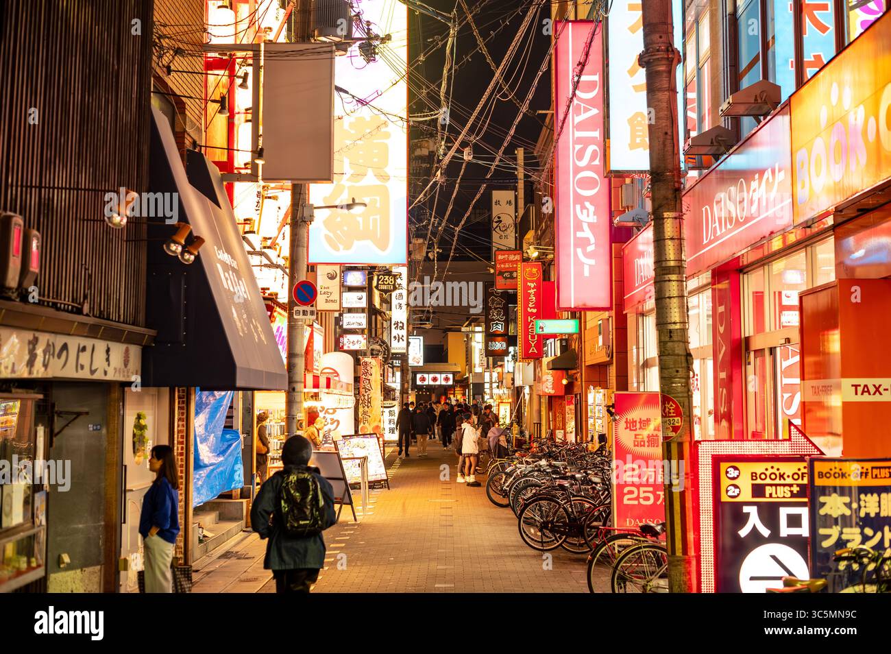 Bright Commercial Street in Osaka at Night with Daiso and Bicycles ...