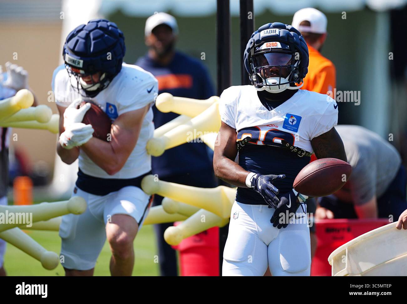 Denver Broncos running back Tyler Badie, front, and tight end Caleb ...