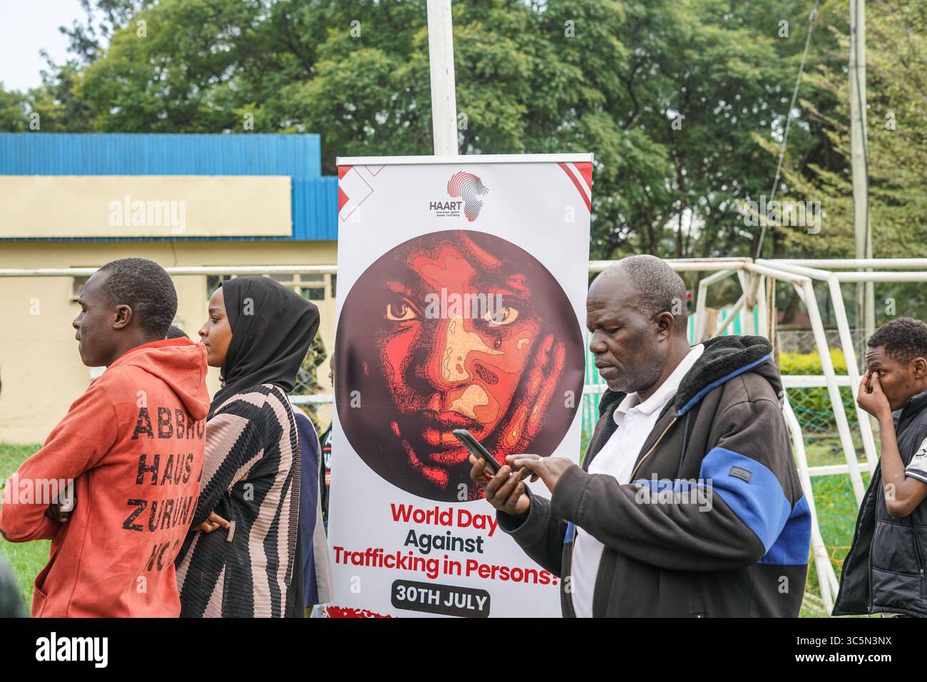 Participants stand beside a banner during commemorations to mark World ...