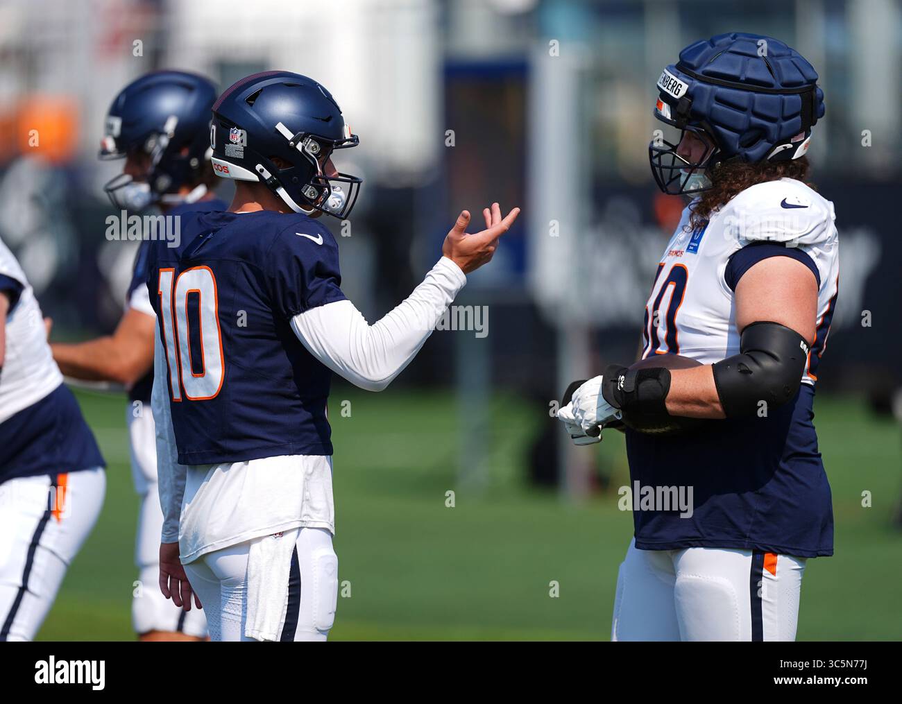 Denver Broncos quarterback Bo Nix, left, confers with center Luke ...