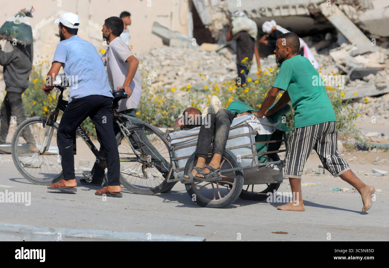 People carry Palestinian men injured by Israeli army fire while waiting ...